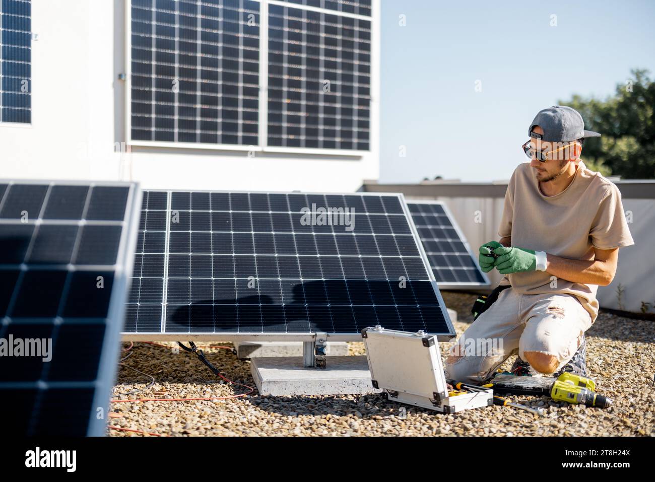 Man installing solar panels on the roof of his house Stock Photo - Alamy