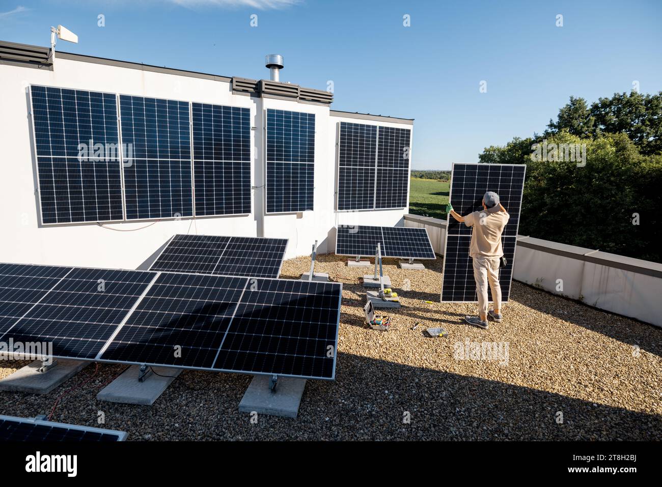 Man installing solar panels on a rooftop Stock Photo - Alamy
