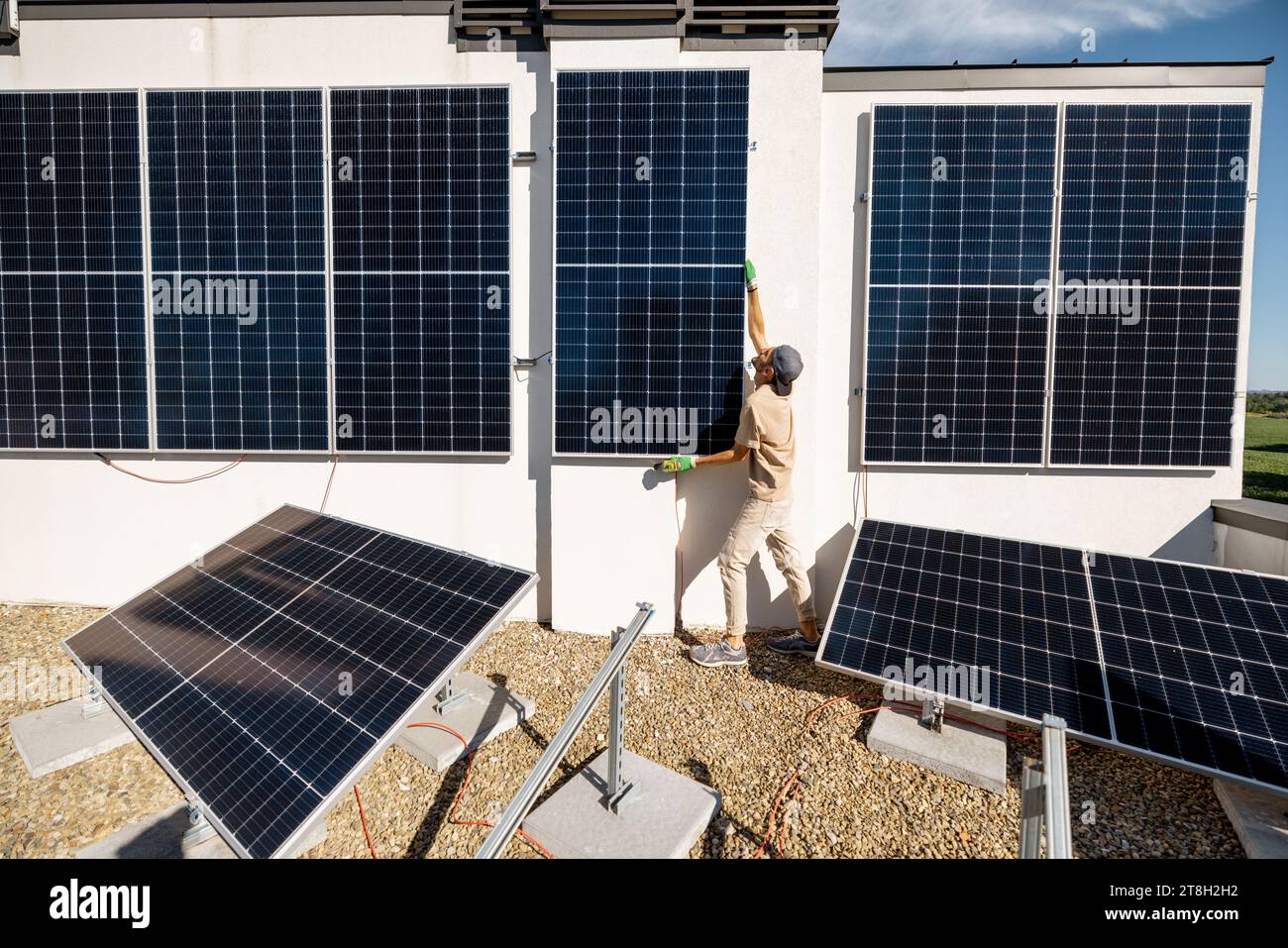 Man installing solar panels on a rooftop Stock Photo - Alamy