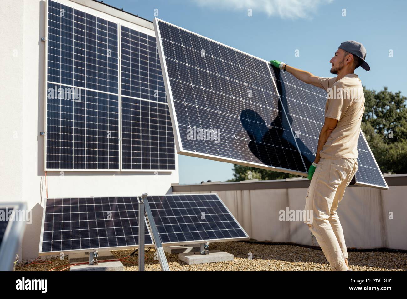 Man installing solar panels on a rooftop Stock Photo - Alamy