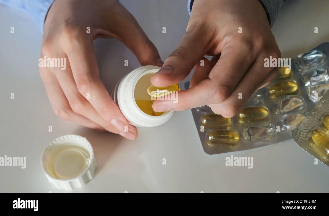 Putting Yellow Medical Pills in Jar. Drugs for course of treatment ...