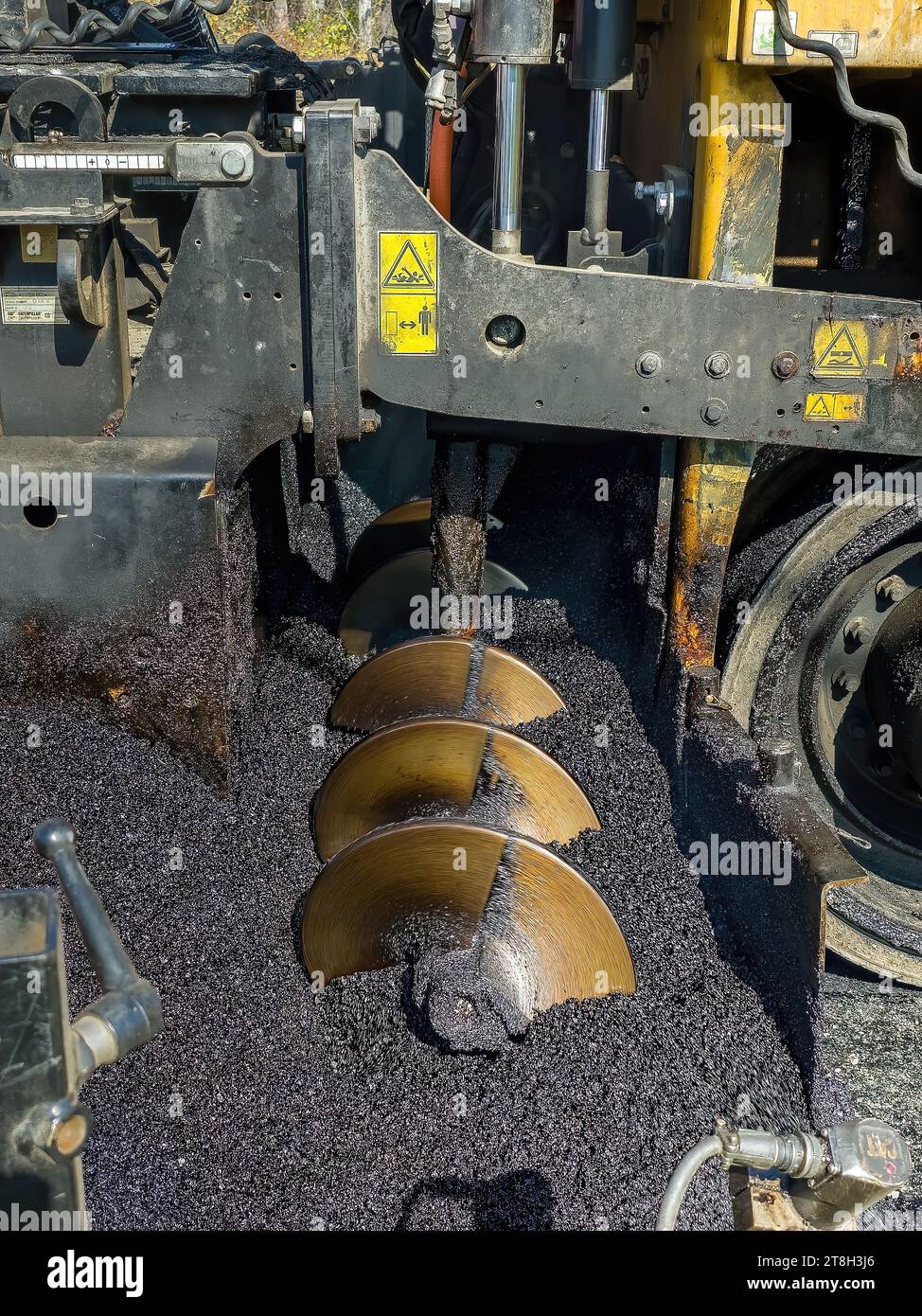 Screw of a paving machine in motion to distribute asphalt Stock Photo ...