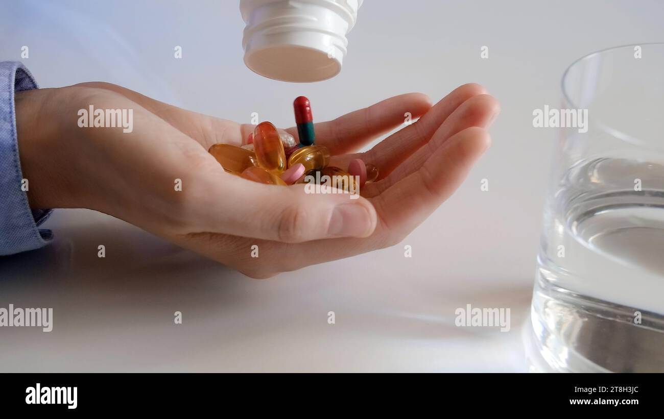 Various Medicine Pills, Tablets and Vitamins on Female Hand. Glass of ...