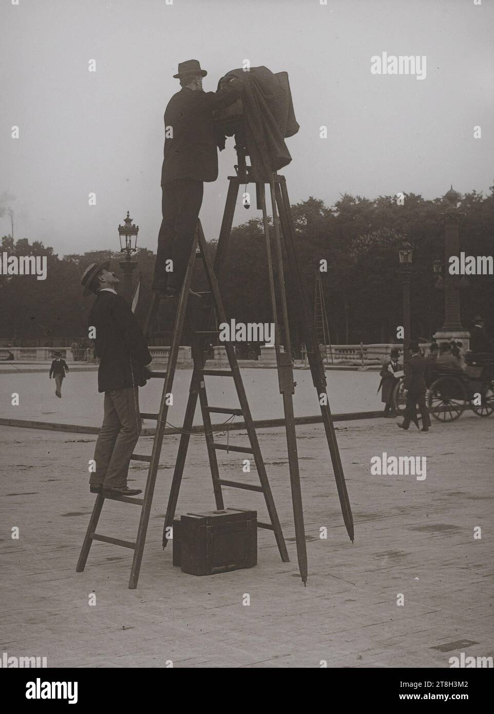 Photographer mounted on a ladder with his camera and photographic ...
