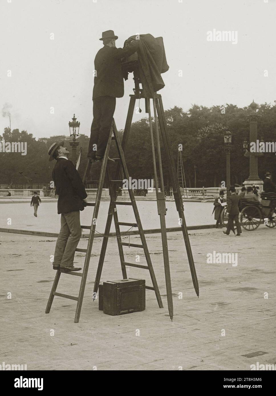 Photographer mounted on a ladder with his camera and photographic ...