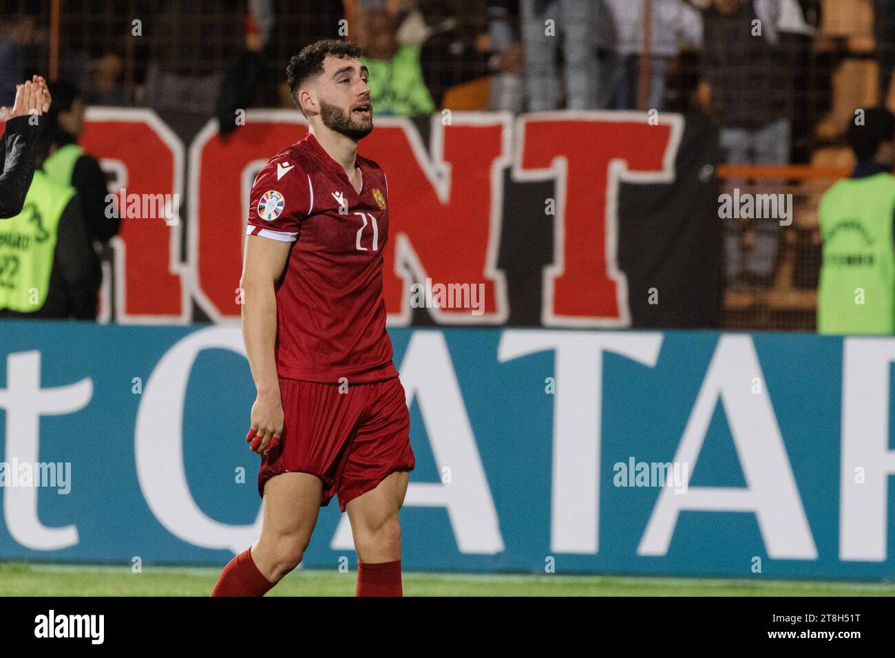 A soccer player is shown walking off the field and displaying a wide ...