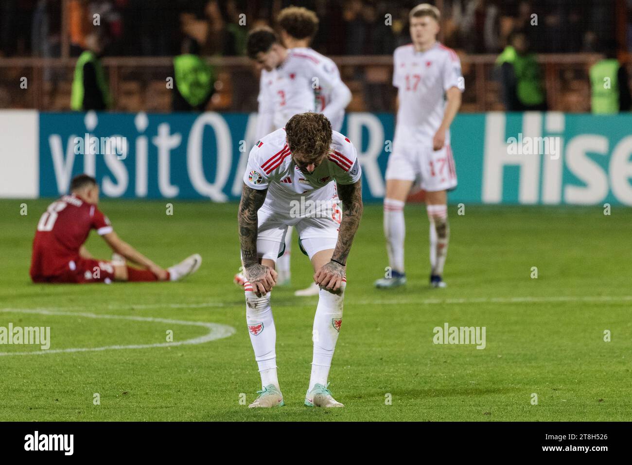 A mid-action shot of a soccer player running on the field, with a ...