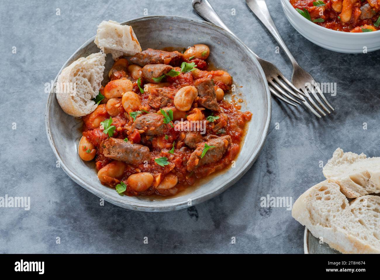 Beef chipolatas and bean casserole with crusty bread Stock Photo - Alamy