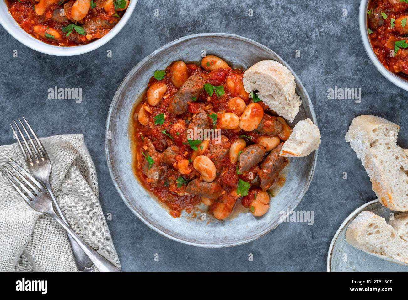 Beef chipolatas and bean casserole with crusty bread Stock Photo - Alamy