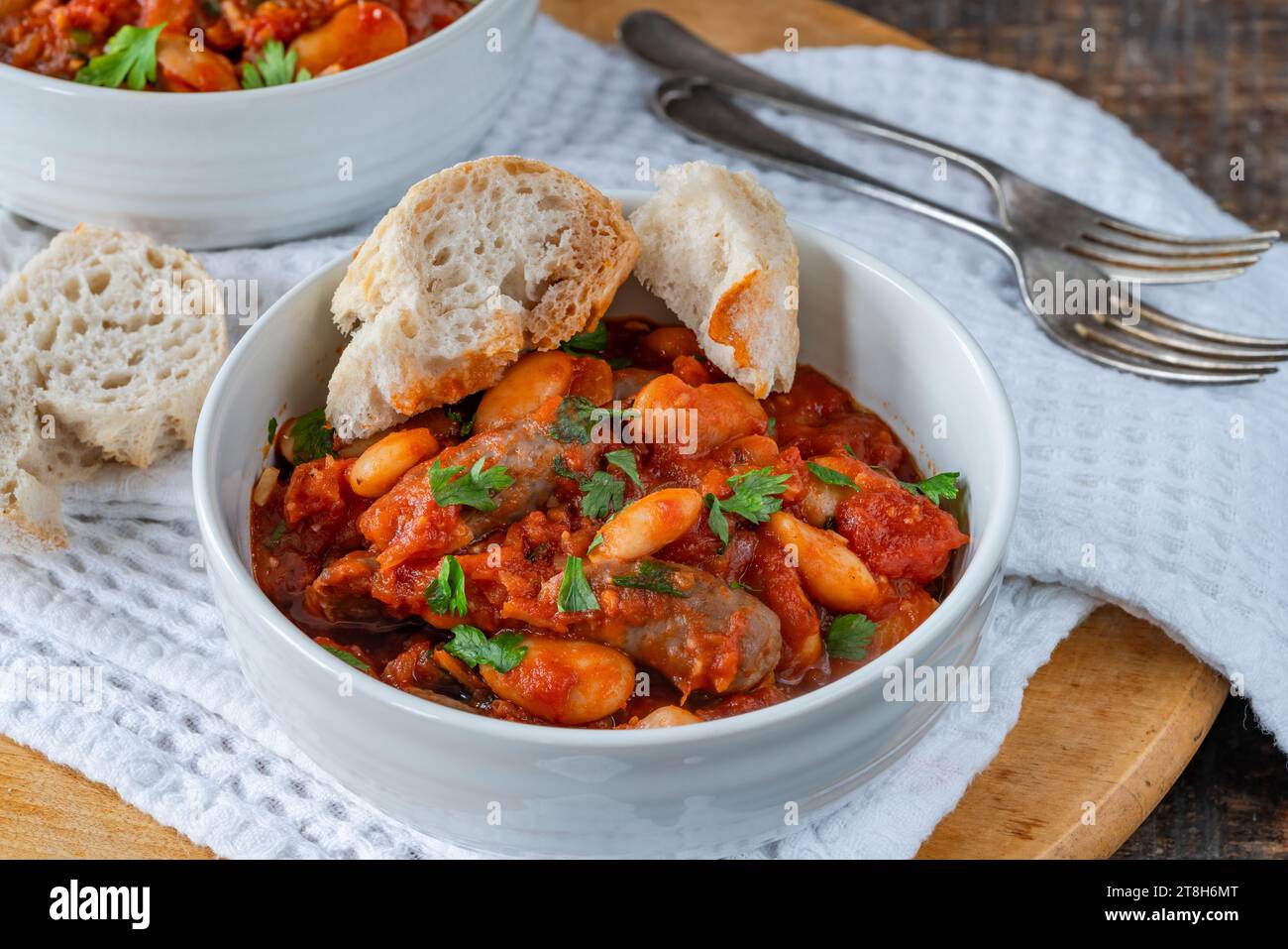 Beef chipolatas and bean casserole with crusty bread Stock Photo - Alamy