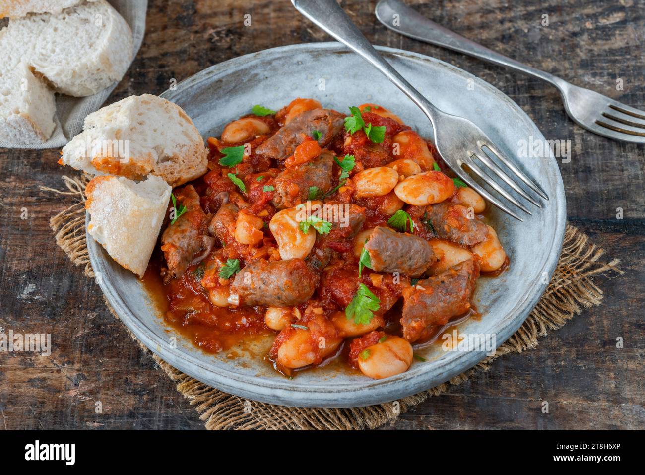 Beef chipolatas and bean casserole with crusty bread Stock Photo - Alamy