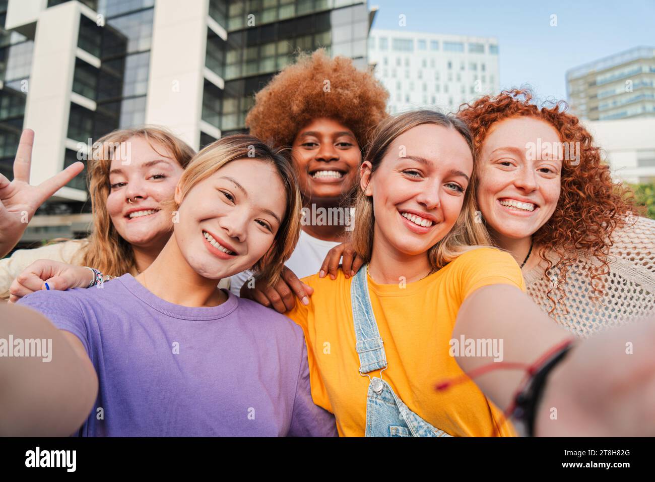 Group of young feminine women taking a selfie portrait, smiling looking at camera. Teenage girls ...