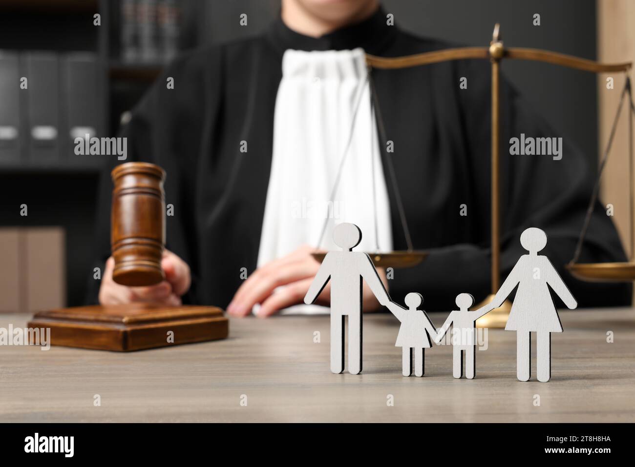 Family law. Judge with gavel and scales of justice sitting at wooden ...