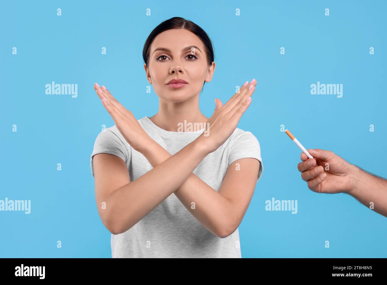 Stop smoking concept. Woman refusing cigarette on light blue background ...