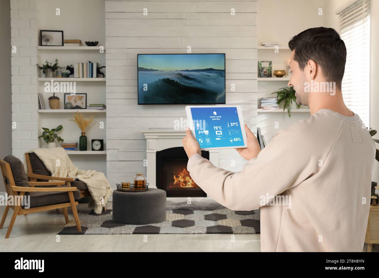 Man Using Smart Home Control System Via Application On Tablet Indoors