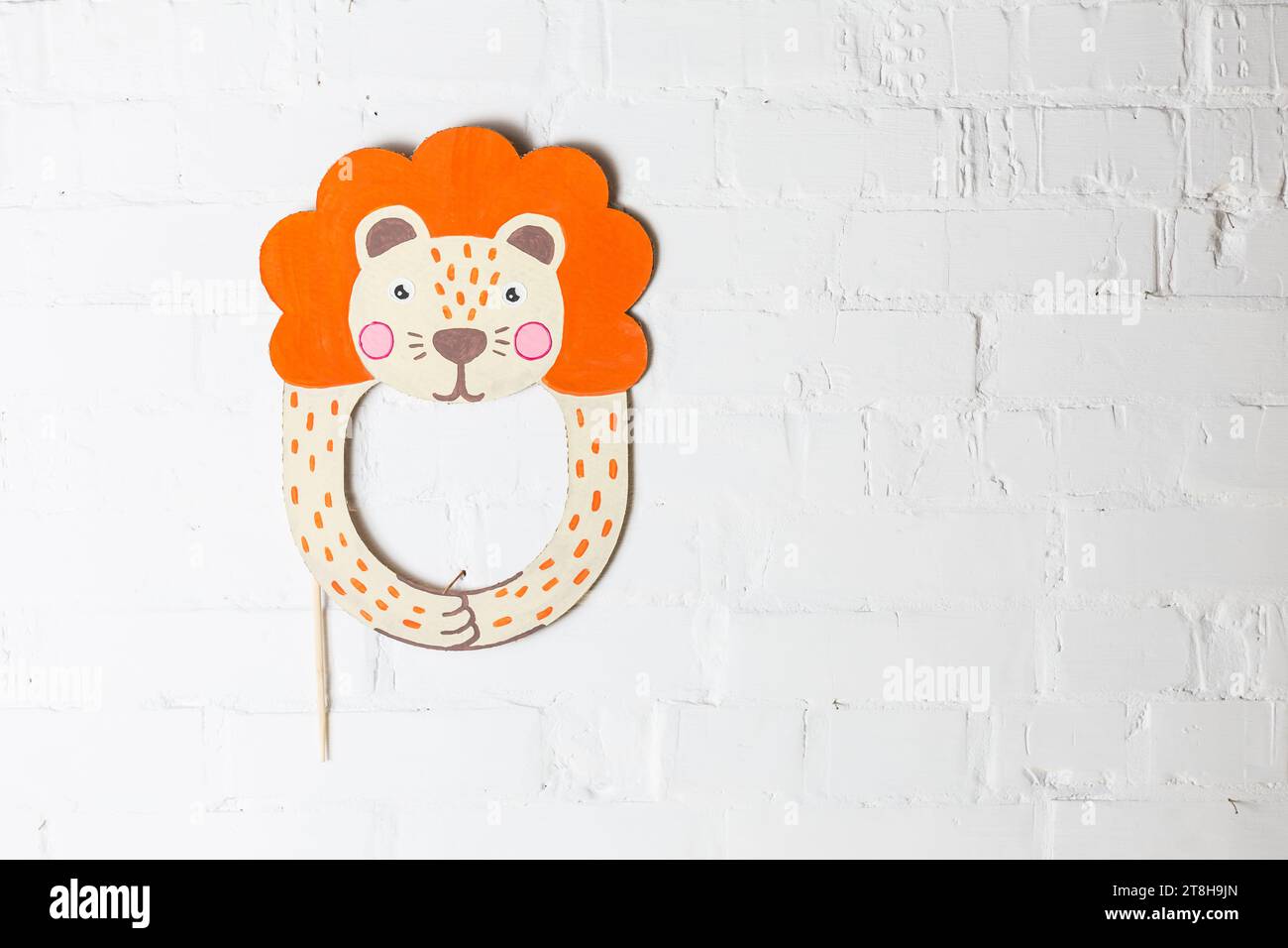 Bright cardboard mask on a white brick wall Stock Photo - Alamy