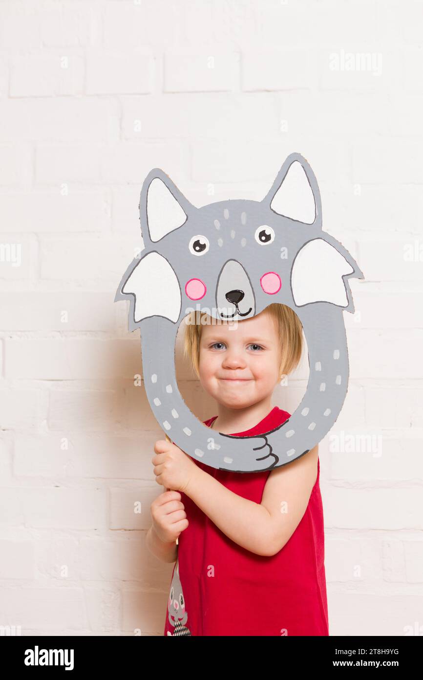 Little girls holding wolf mask on white background Stock Photo - Alamy