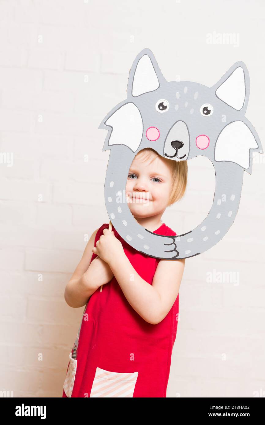 Little girls holding wolf mask on white background Stock Photo - Alamy