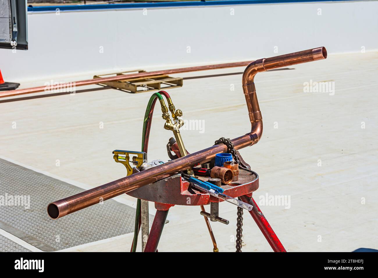 A length of copper pipe secured to a workbench for brazing, on the roof ...