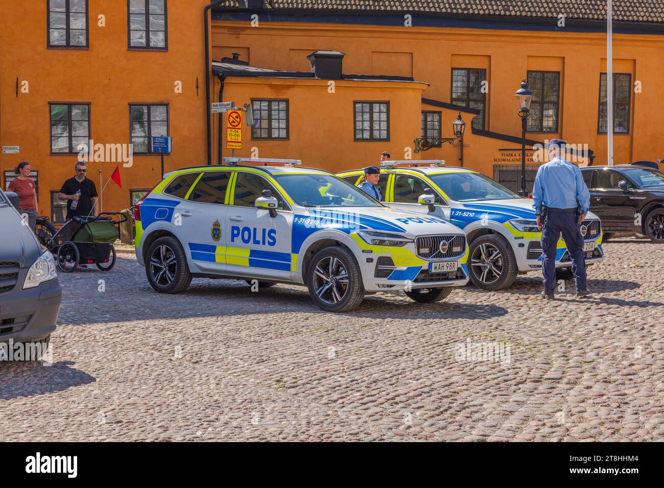 View of two police officers near their patrol cars, communicating with ...