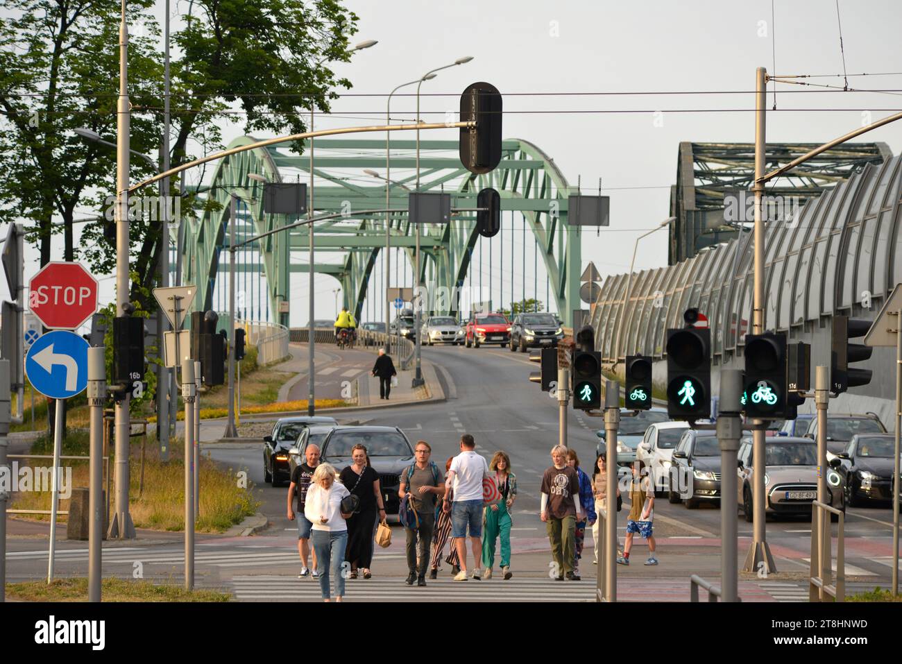 Pedestrians crossing street at green traffic lights at a busy crossroad ...