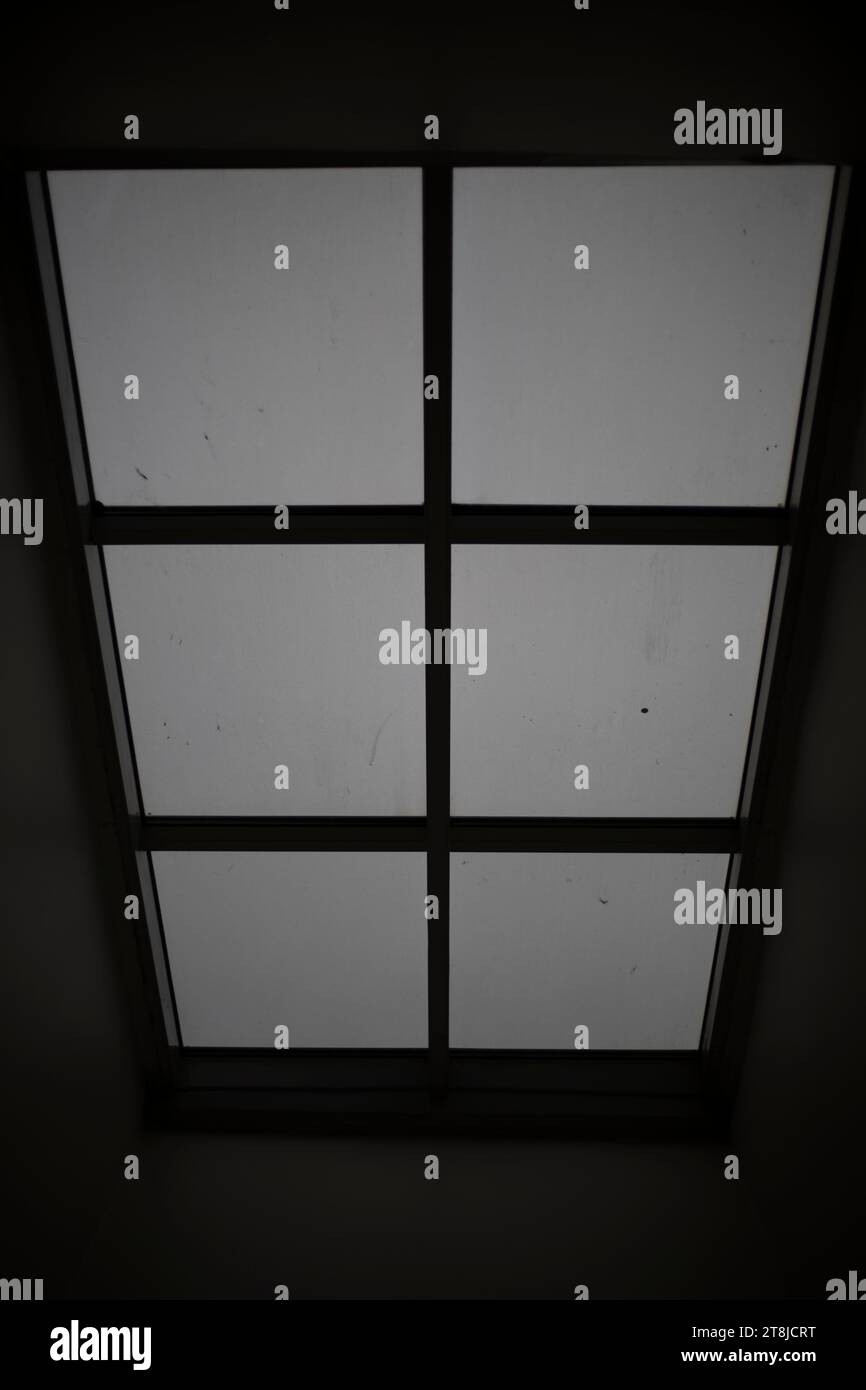 Large window in the ceiling. Faint light through glass. Grey day ...