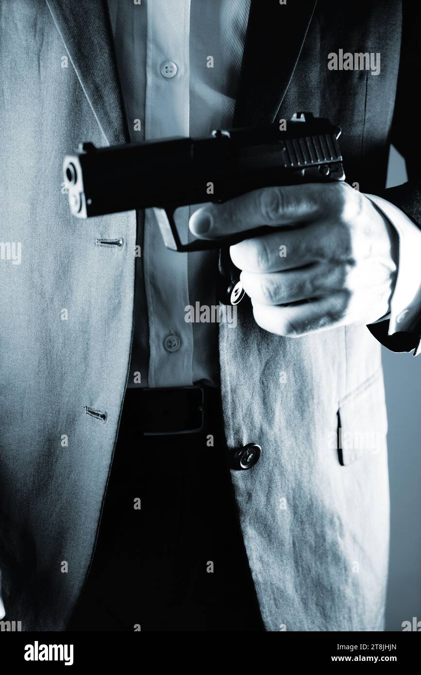 Retro secret agent with pistol revolver gun in hand in vintage crime ...