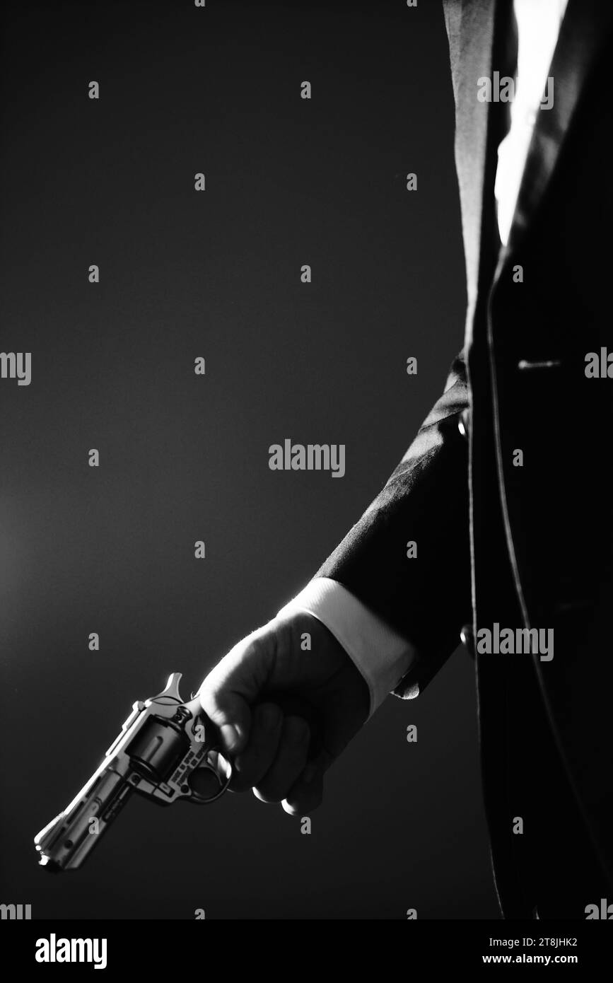 Retro secret agent with pistol revolver gun in hand in vintage crime ...