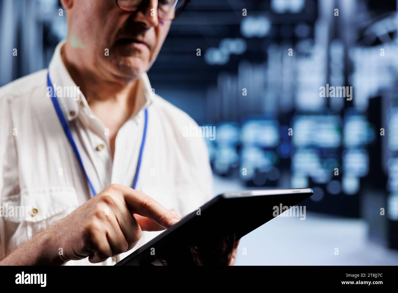 Octogenarian empoyee inspects operational blade servers in computer ...