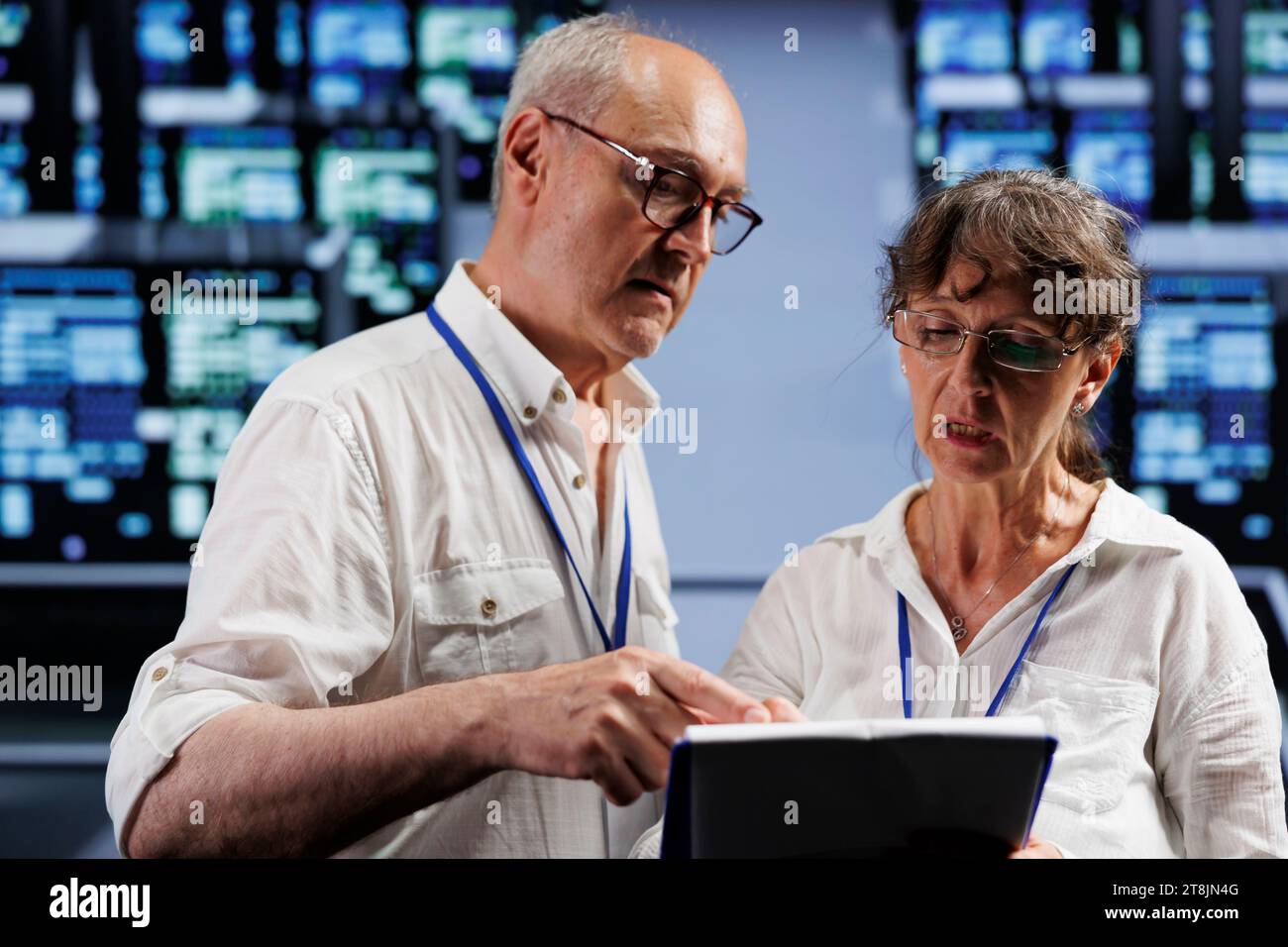 Senior engineers monitoring data center rigs, optimizing them for data processing requirements ...