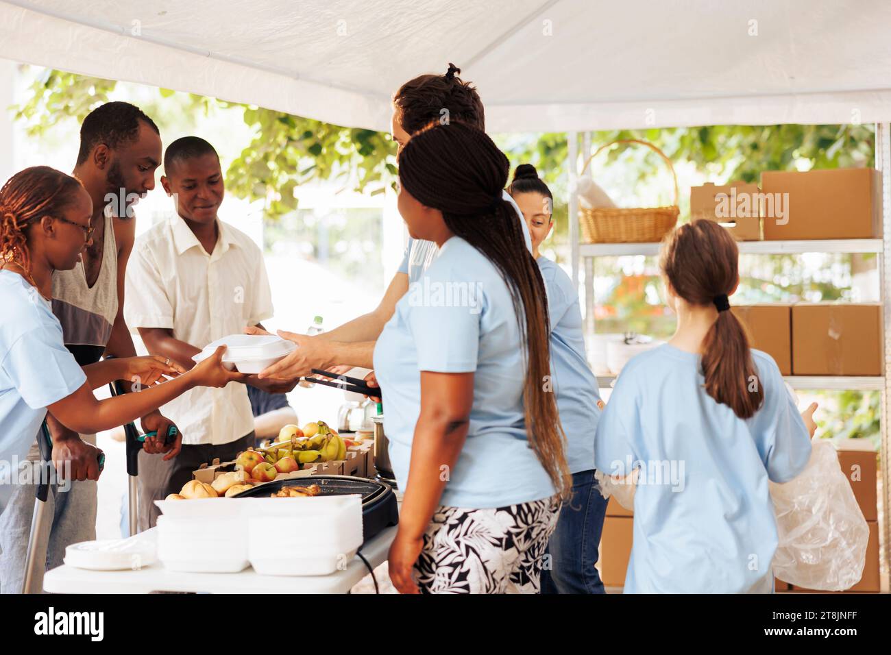 African american woman and multiethnic volunteers helping and giving ...