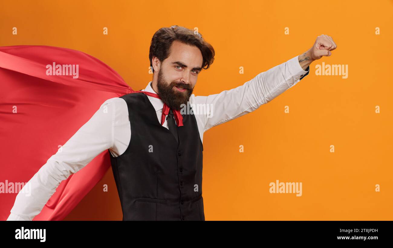 Elegant butler with red cape posing on camera while he acts like ...