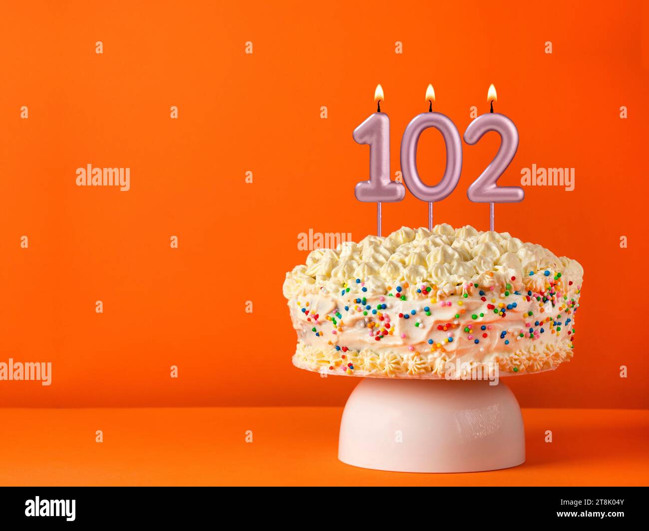 Candle number 102 - Vanilla cake in orange background Stock Photo - Alamy