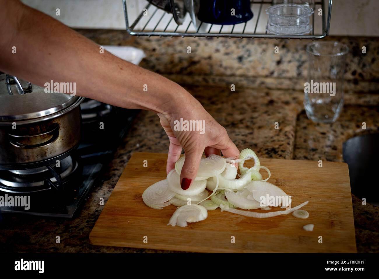 Hand holding sliced onions on a cutting board. Food seasoning Stock ...
