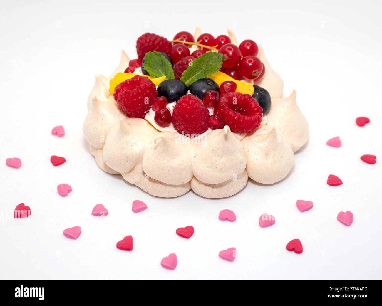 Meringue pavlova dessert, decorated with whipped cream, berries and ...