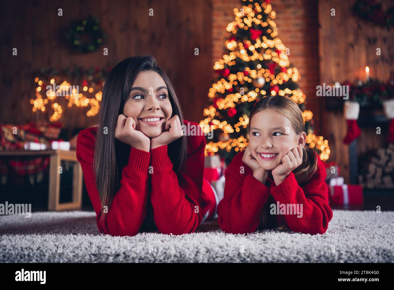 Photo of charming dreamy little siblings dressed red sweaters thinking ...