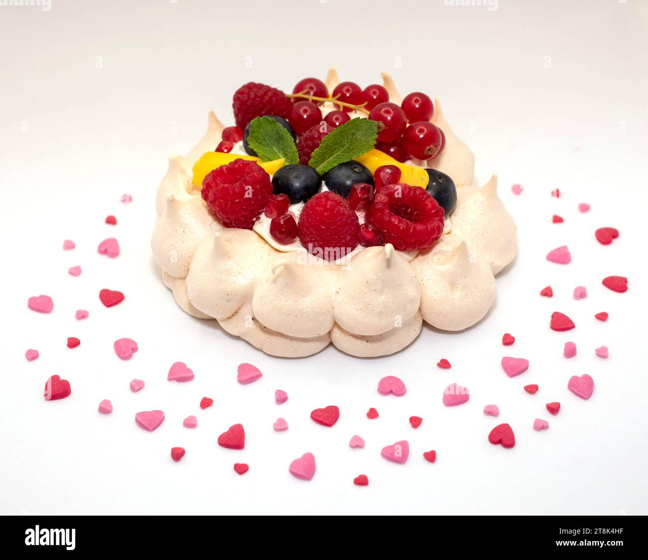 Meringue pavlova dessert, decorated with whipped cream, berries and ...