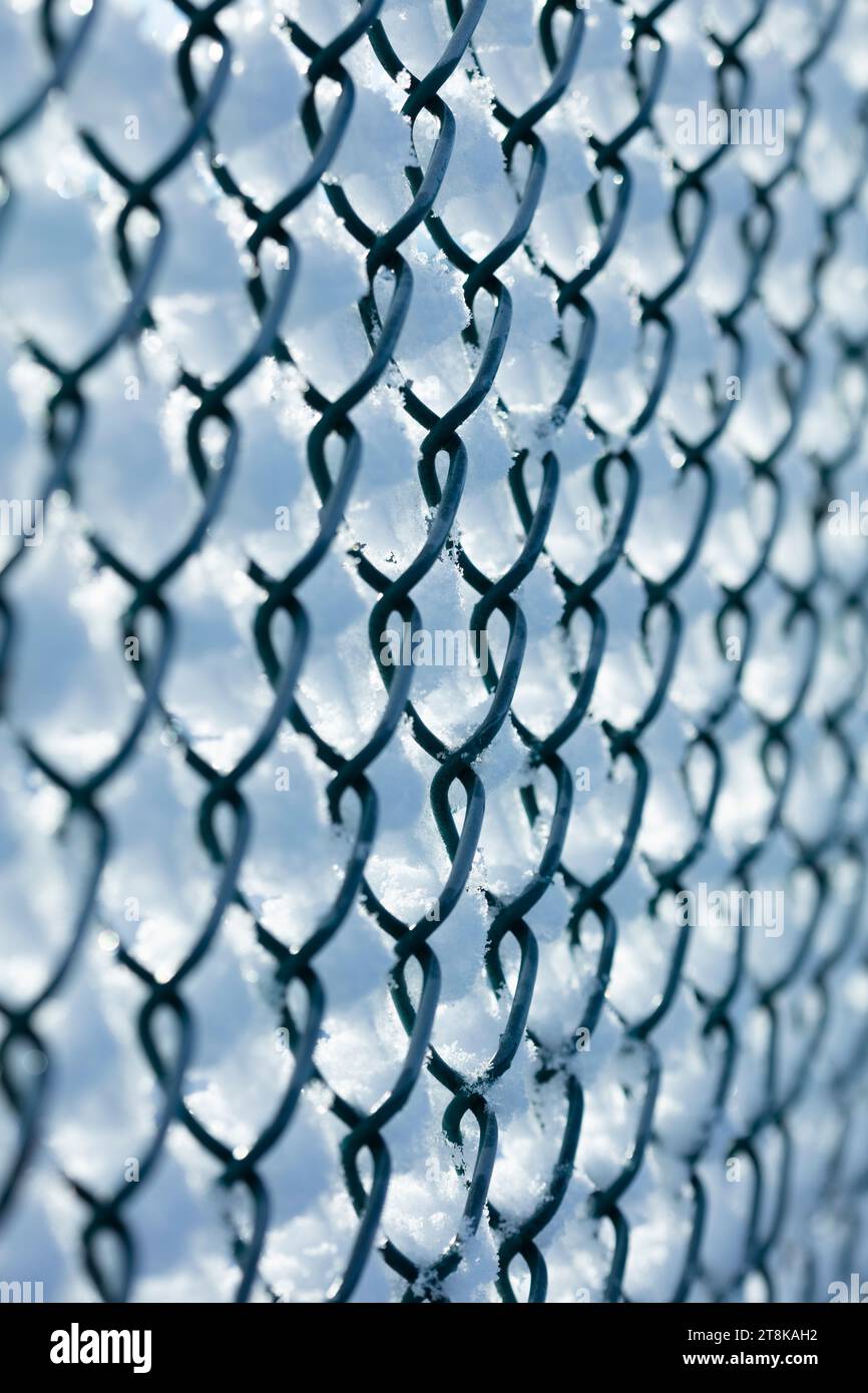 Snow on chain link fence against blue sky Stock Photo - Alamy