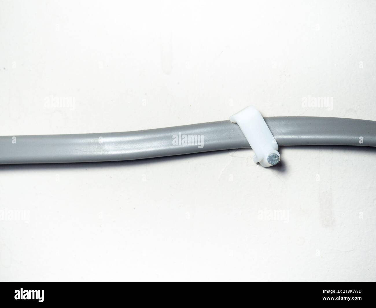 Fastening the wire to the wall. Ceiling mounting. Electric cord in the ...