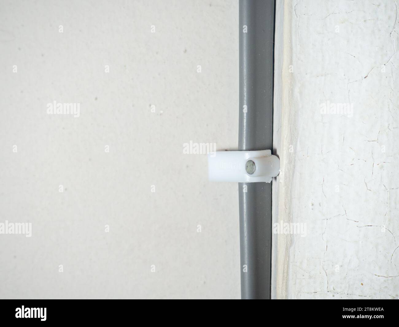 Fastening the wire to the wall. Ceiling mounting. Electric cord in the ...