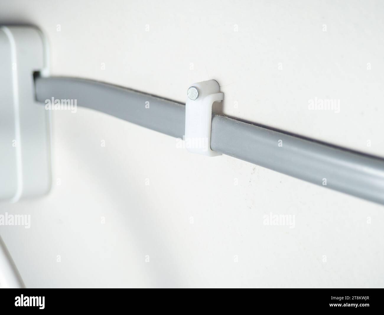 Fastening the wire to the wall. Ceiling mounting. Electric cord in the ...