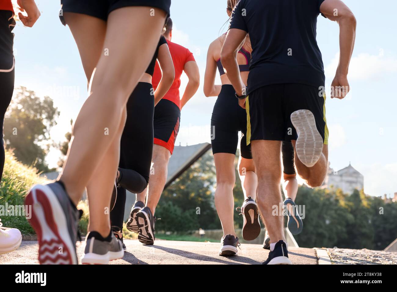 Group of people running outdoors on sunny day, back view Stock Photo ...