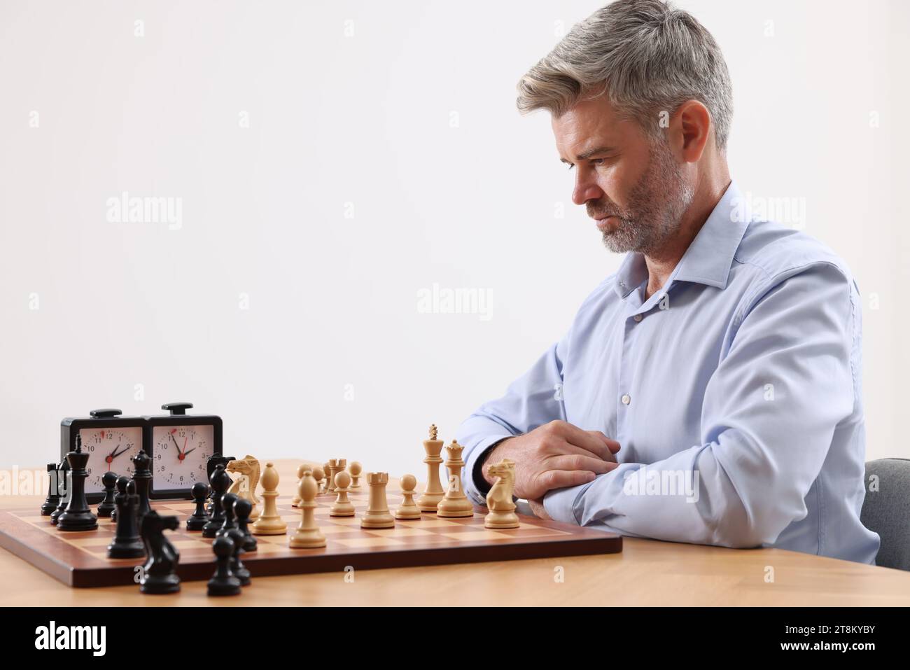 Man playing chess during tournament at table against white background ...