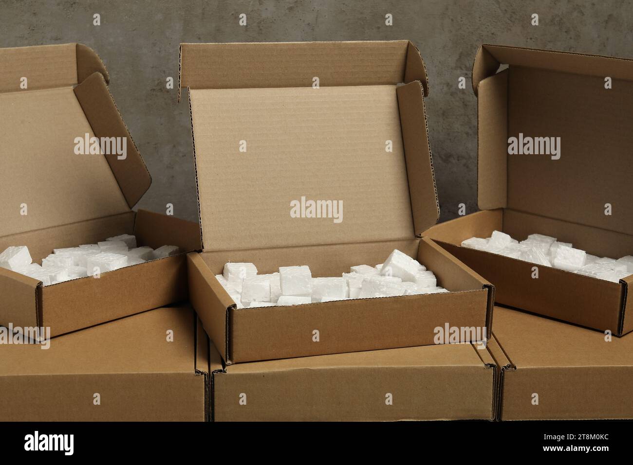 Many closed and open cardboard boxes with pieces of polystyrene foam on ...