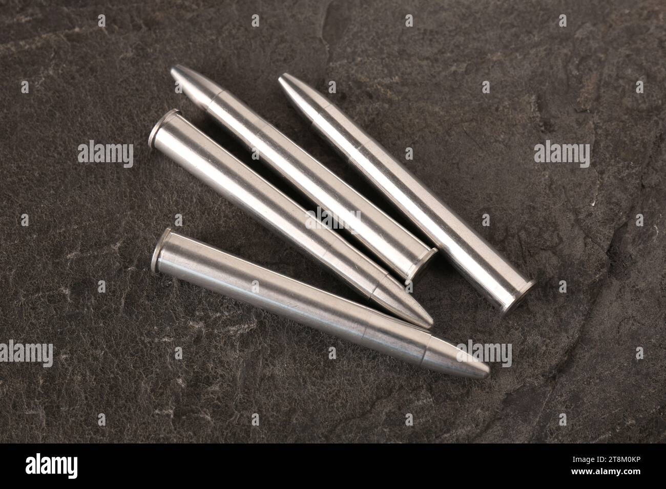 Metal bullets on dark textured table, above view Stock Photo - Alamy