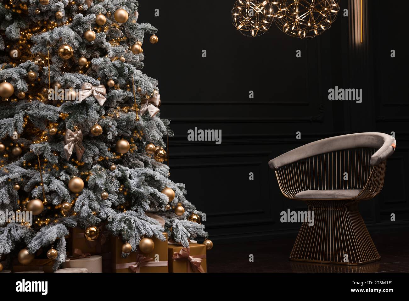 Beautiful decorated Christmas tree, chair and festive decor in dark ...