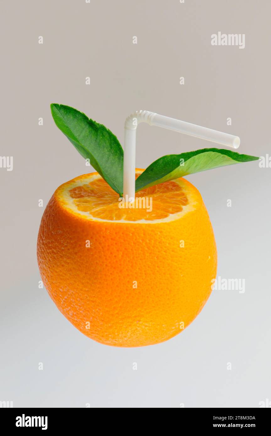 Split orange fruit filled with straw looks fresh with leaf tips Stock ...