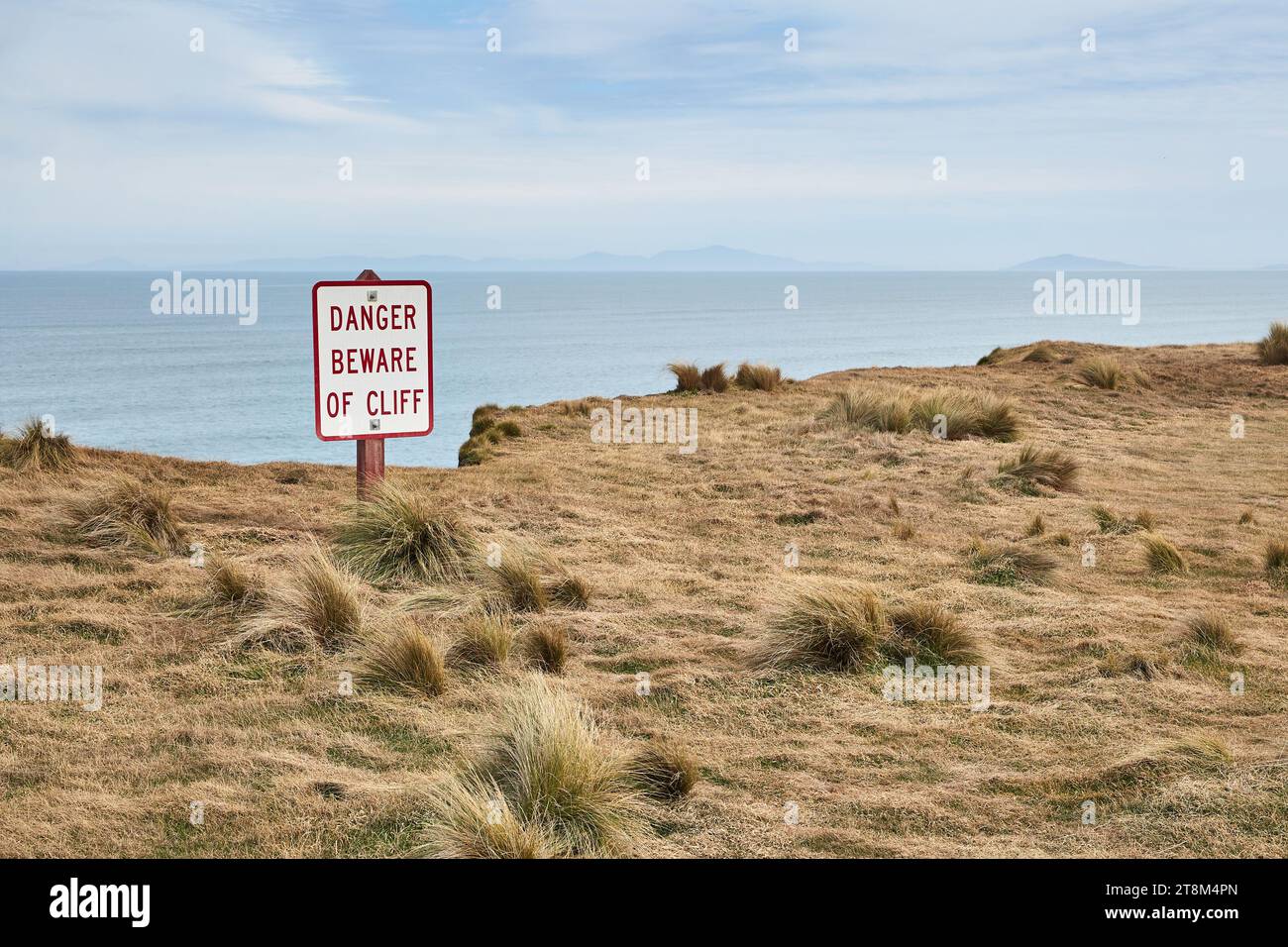 Beware of cliff warning sign, coastal landscape Stock Photo - Alamy