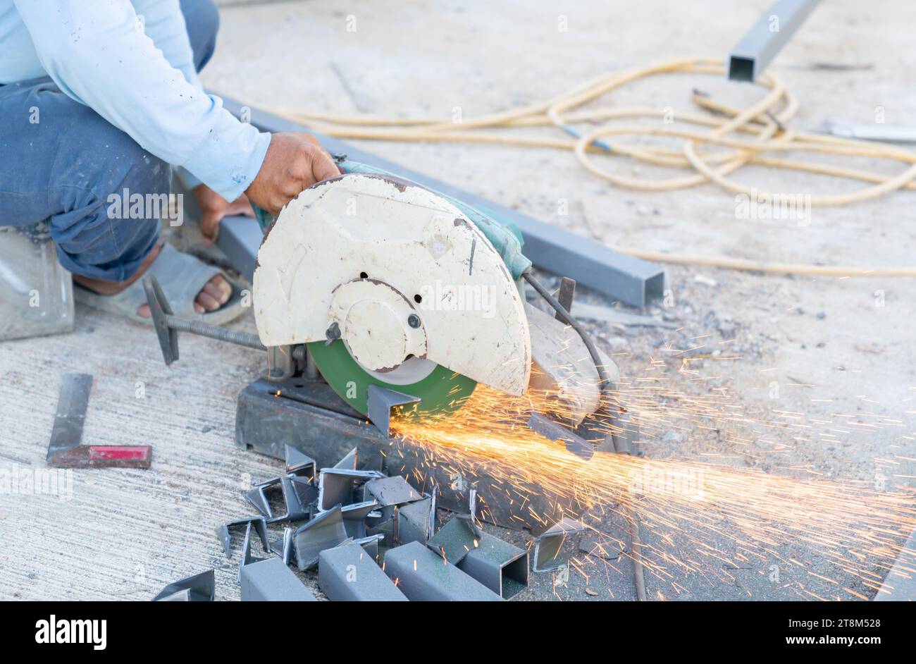 The man is cutting a metal box using circle cut machine and the fire ...