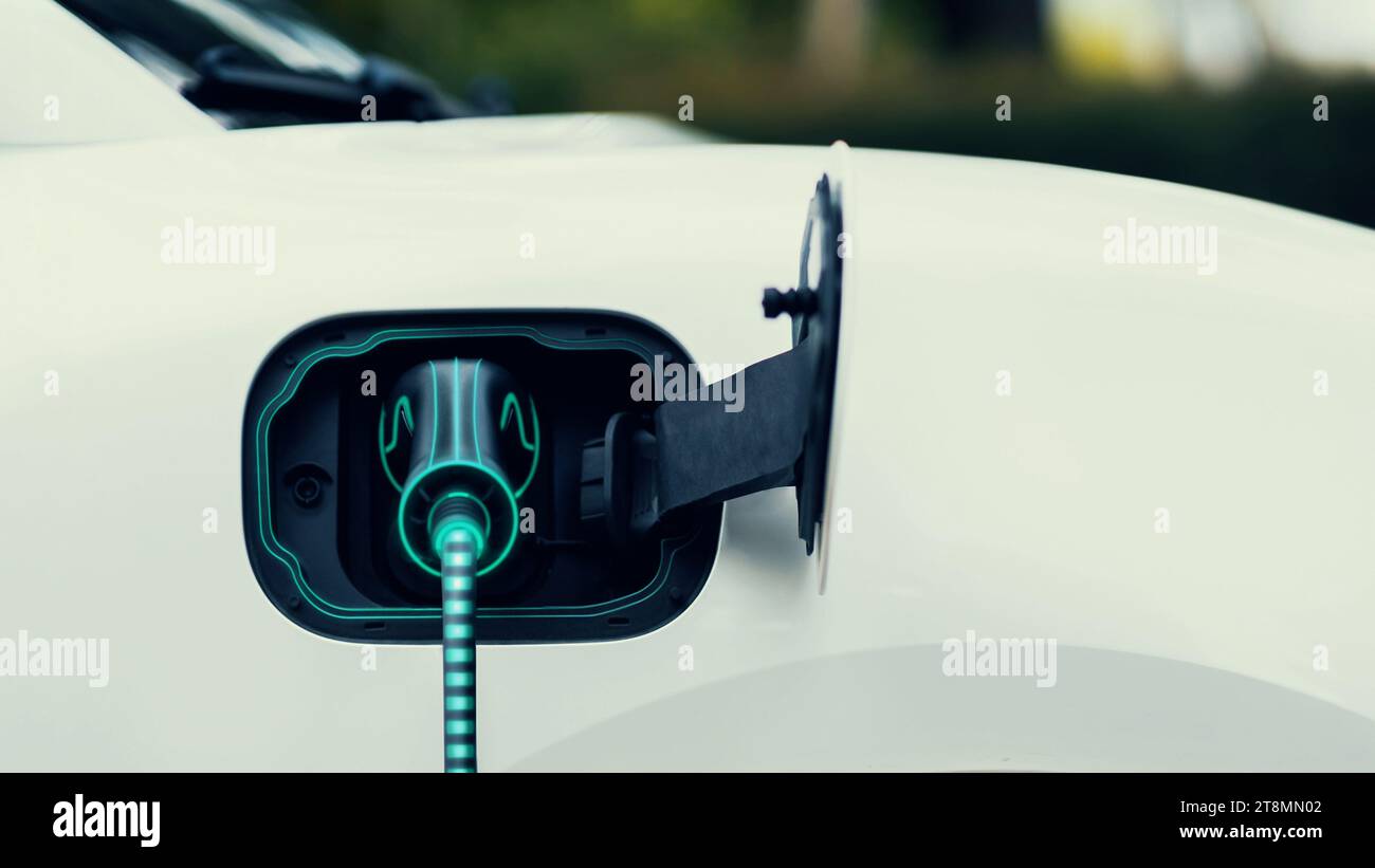 Front view EV charger plugged into electric car for electric recharging ...